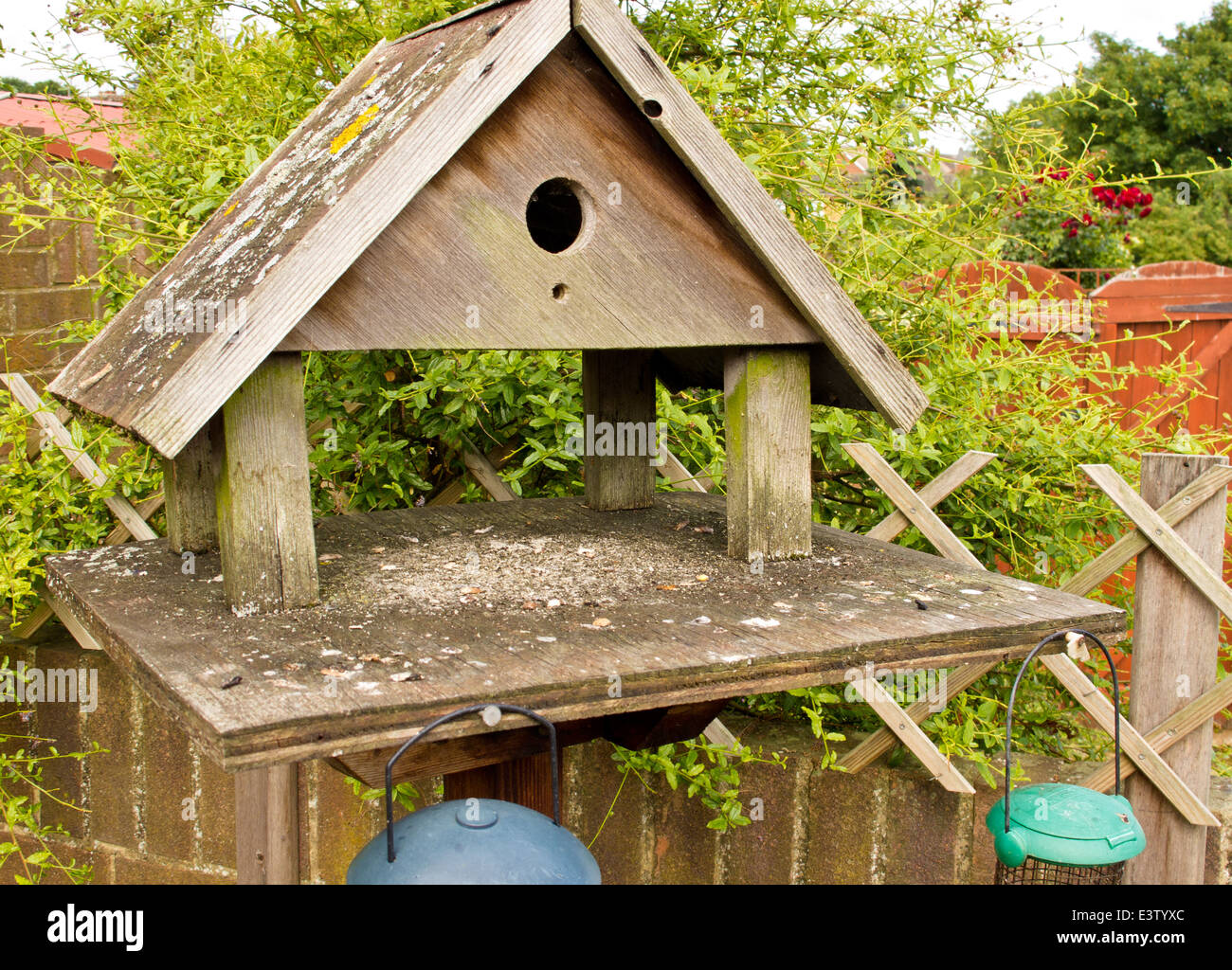 An old garden bird table with feeders hanging Stock Photo - Alamy