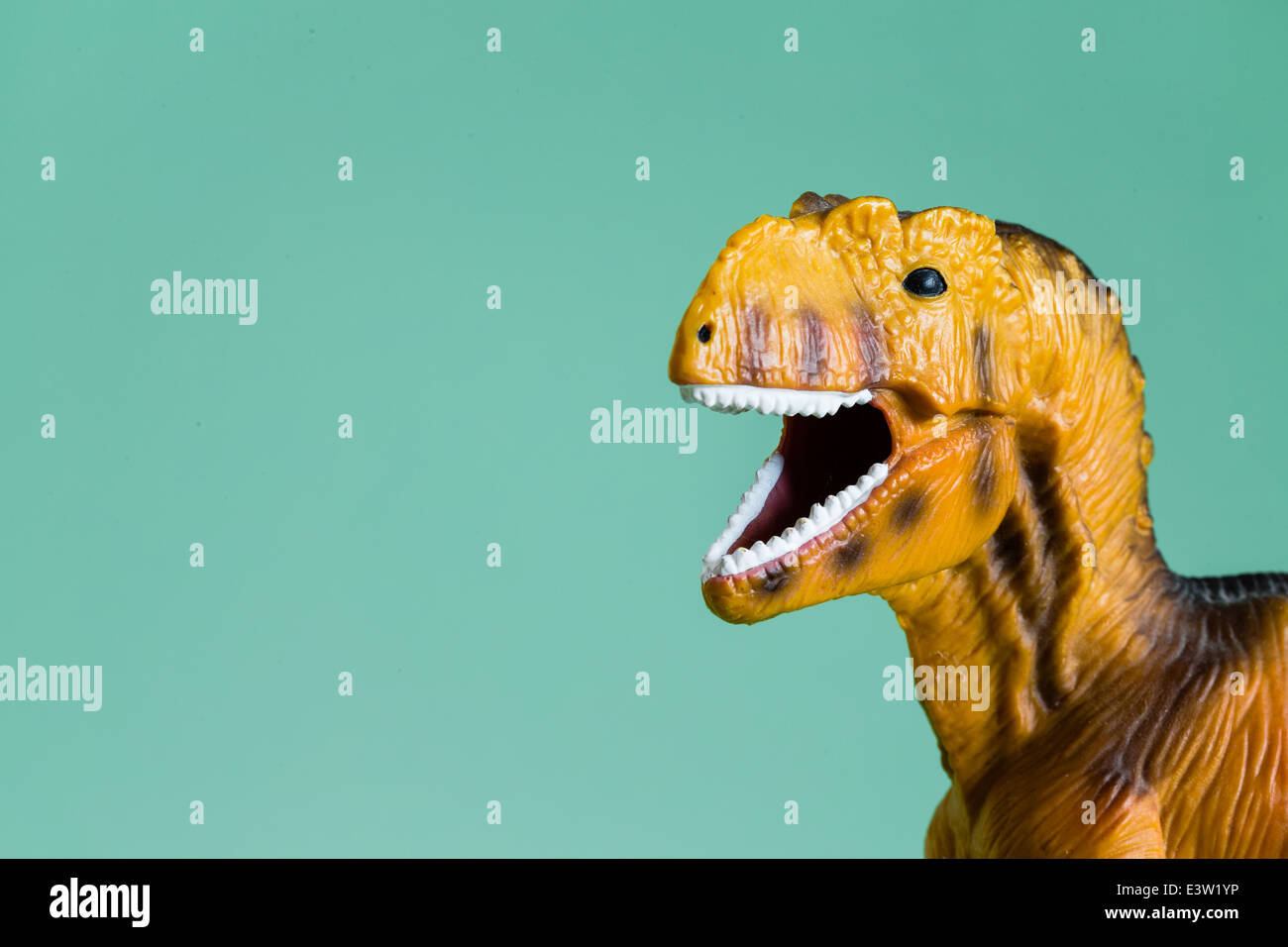Close up of toy T-rex on blue / green background Stock Photo - Alamy