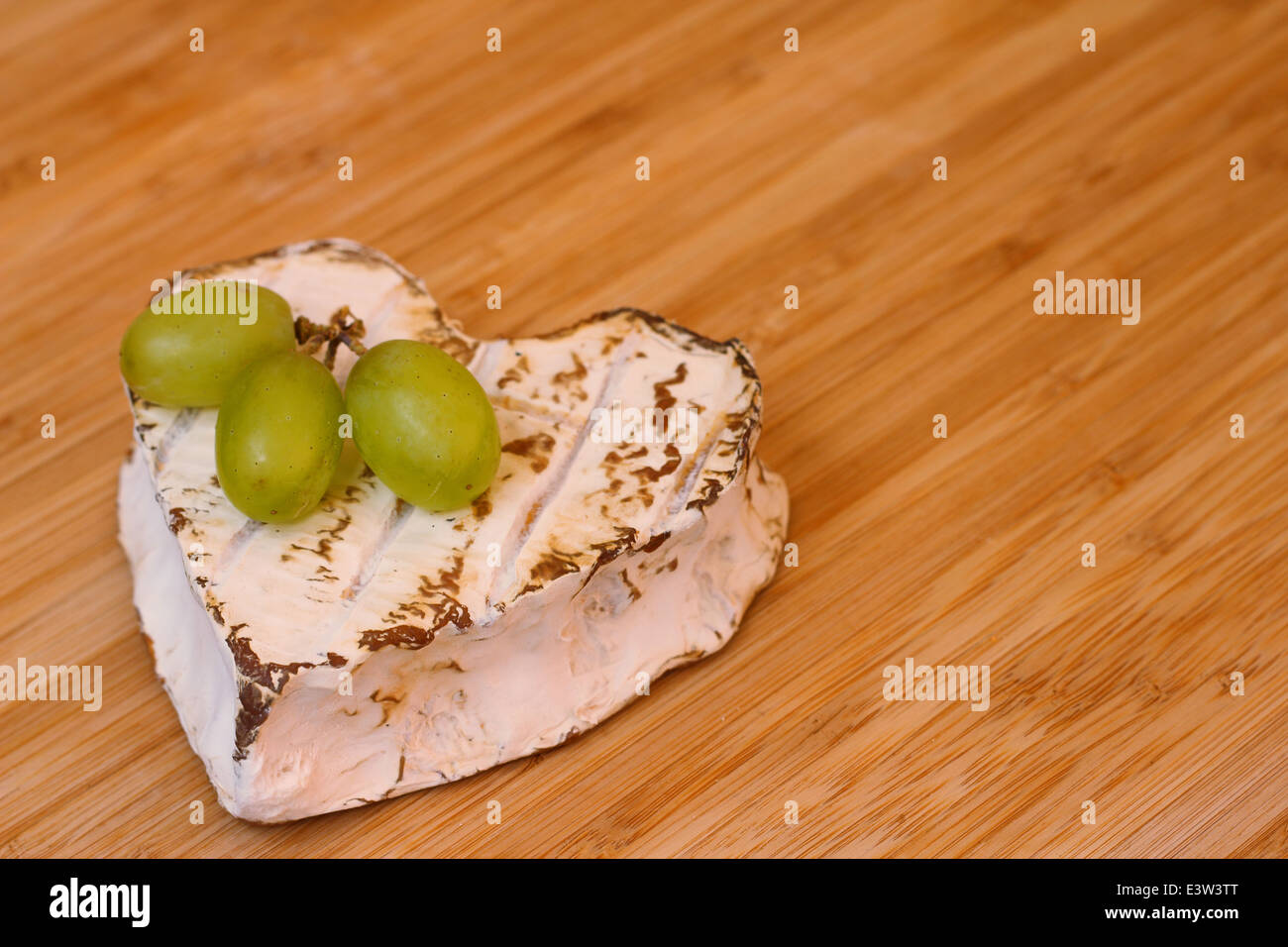 Neufchatel cheese shaped like heart on wooden cutting board Stock Photo ...