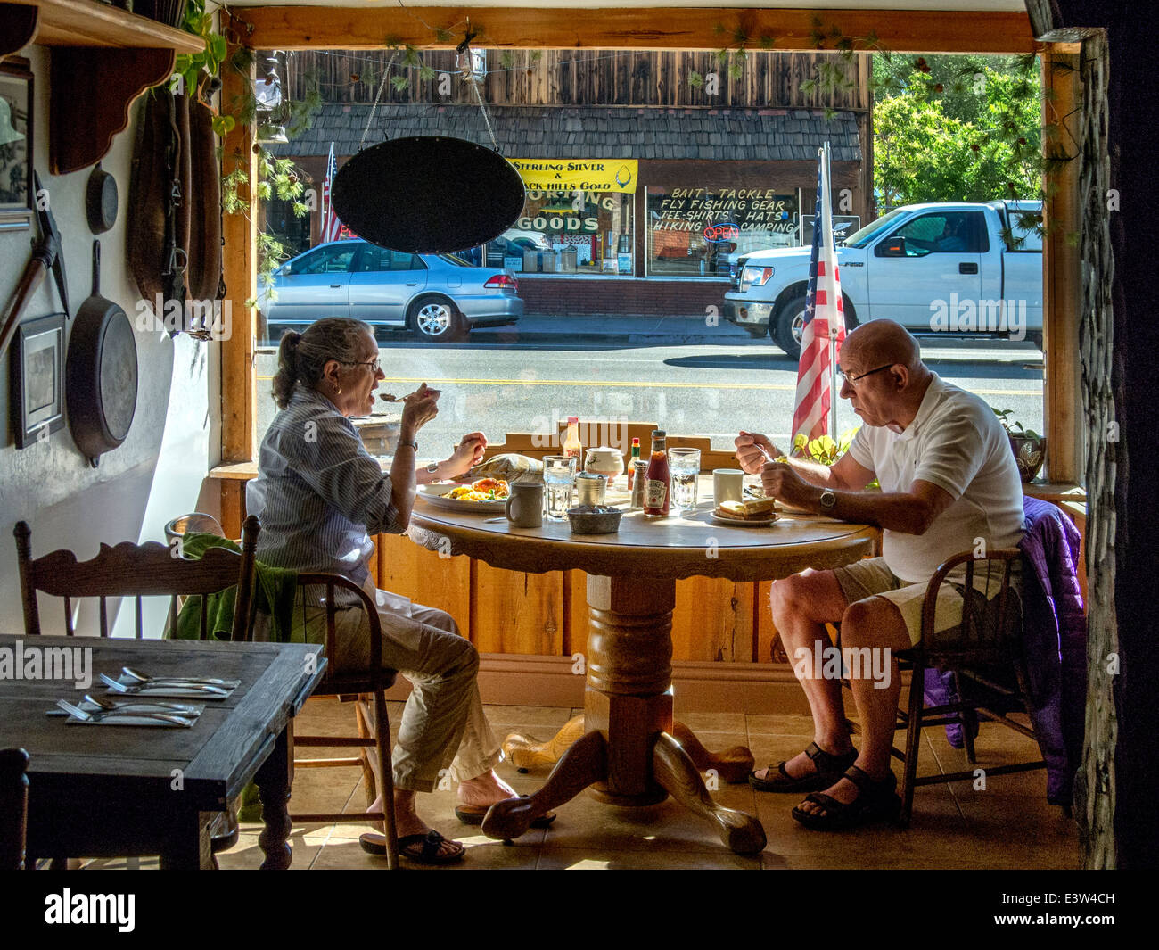 An elderly couple eat breakfast by the window of a restaurant on the ...