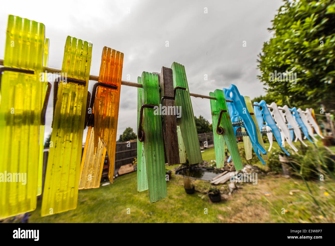Looks like rain. Mixture of clothes pegs on empty washing line. Wooden ...