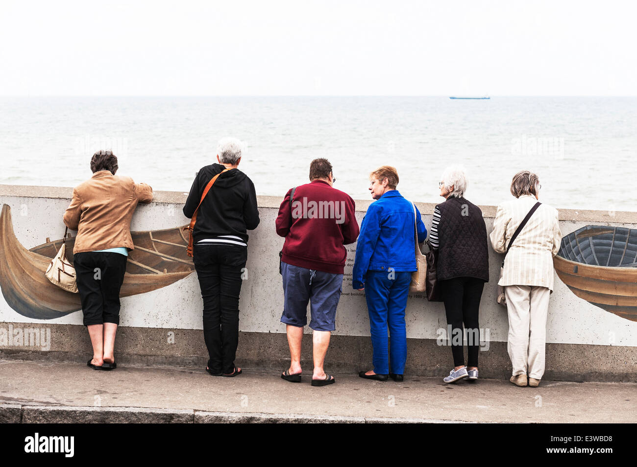 A group of friends looking over a wall at Sherringham Stock Photo - Alamy