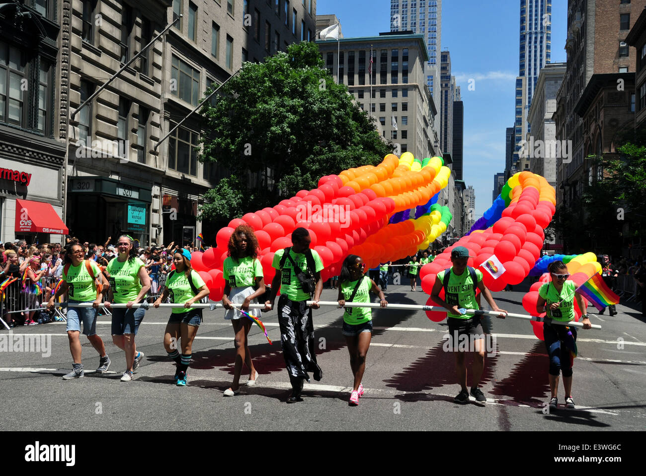 NYC: Event staff members leading the rainbow colour balloon arches at the start of the 2014 Gay ...