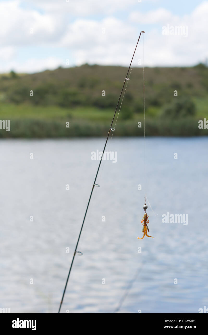 Fishing pole with bait against lake and beautiful sky Stock Photo - Alamy