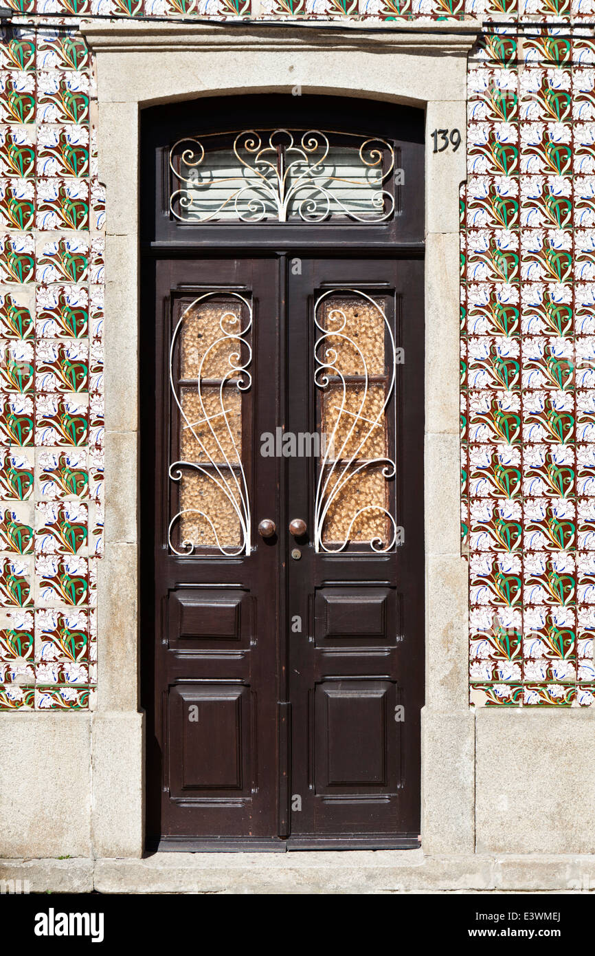 Floral motifs painted on azulejos tiles surround a traditional doorway ...