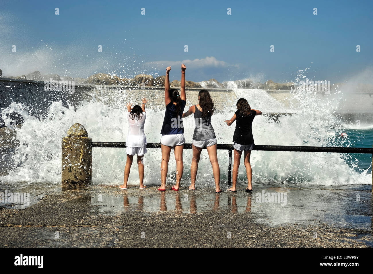 Young girls playing with waves Stock Photo - Alamy