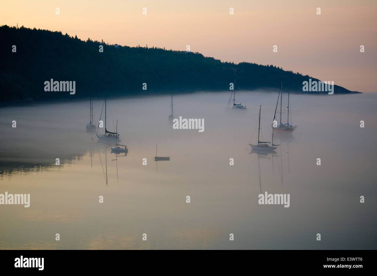 Anchored boats in the mist offshore in Tadoussac Bay, on the Gaspé ...