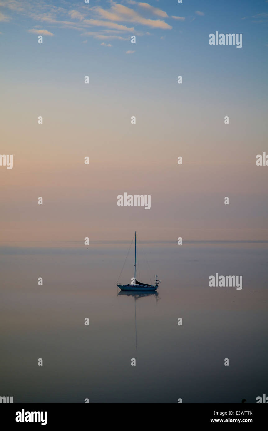 Anchored boat in the mist offshore in Tadoussac Bay, on the Gaspé ...