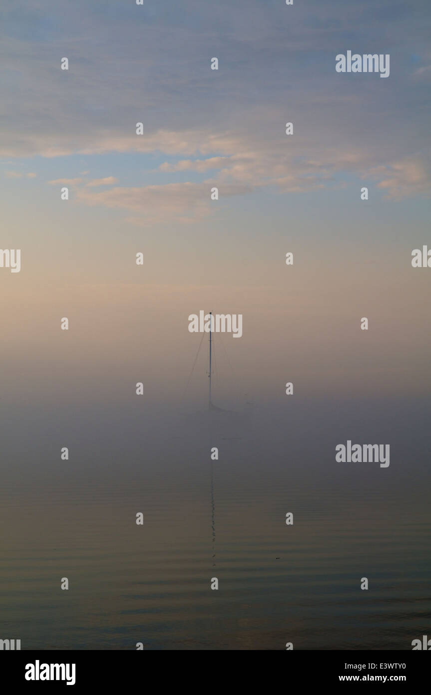 Anchored boat in the mist offshore in Tadoussac Bay, on the Gaspé ...