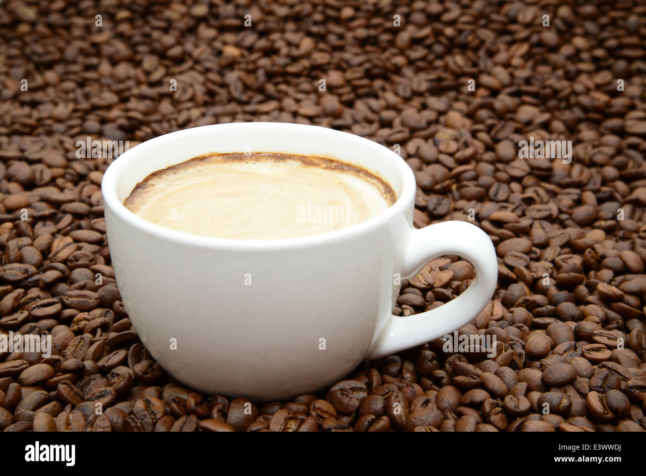 cup of coffee with cream on a coffee beans background Stock Photo - Alamy