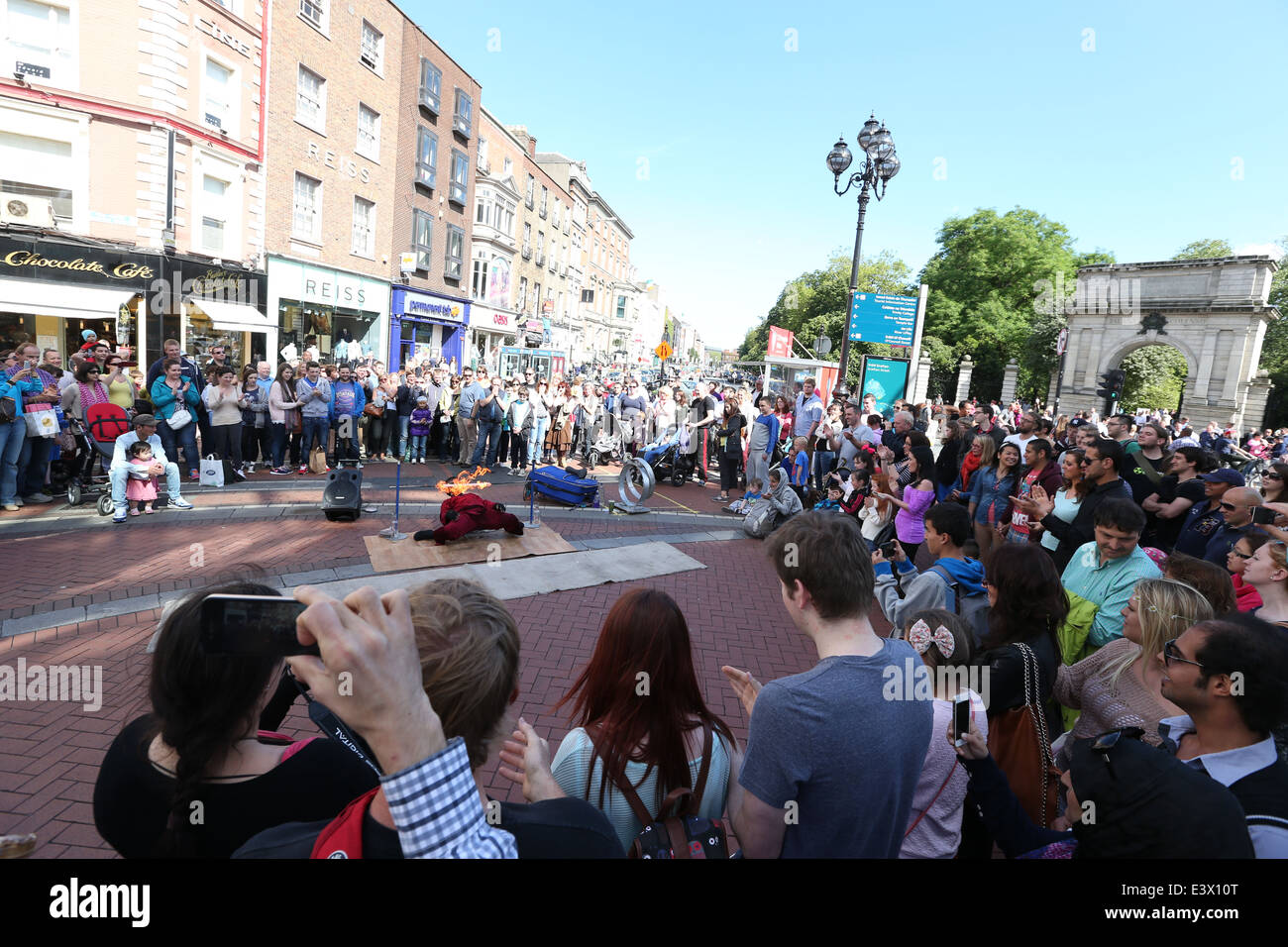 A street performer entertains a crowd of people at the top of Grafton ...