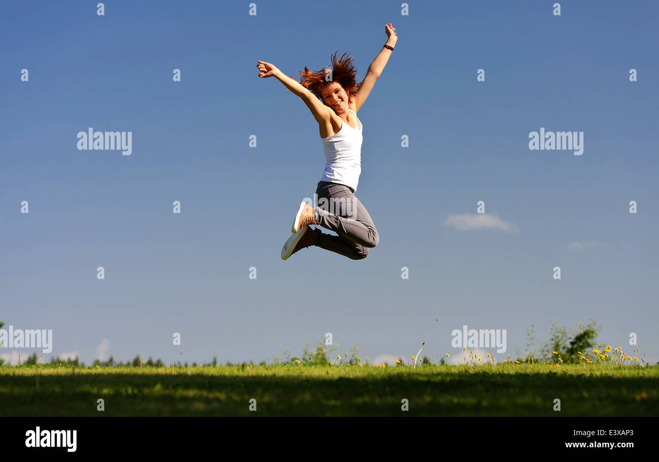 Young woman jumping outside Stock Photo - Alamy