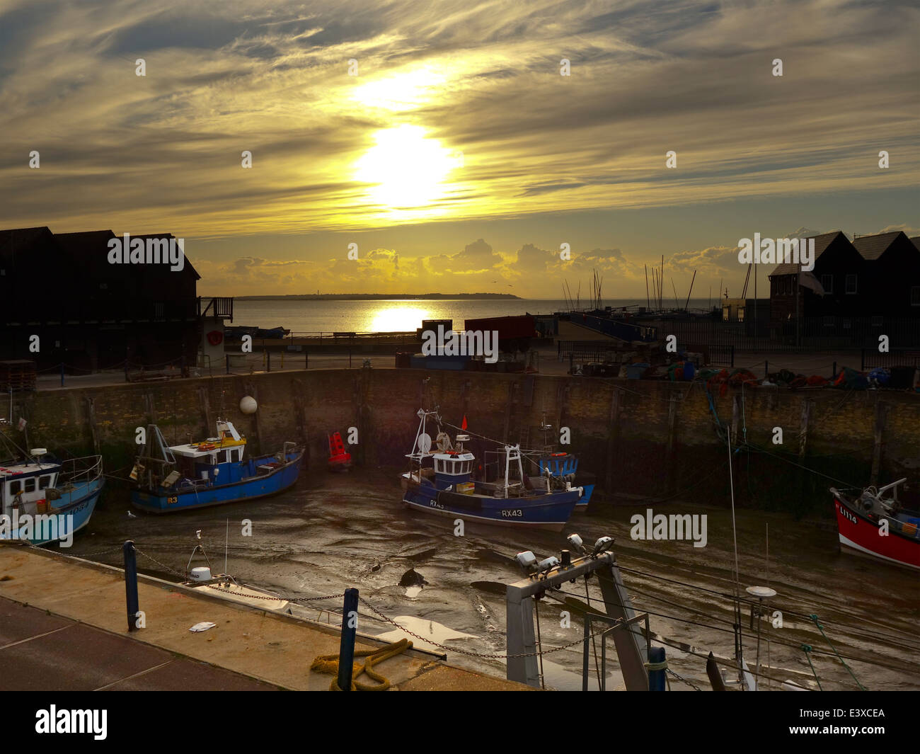 Whitstable harbour sunset low tide Stock Photo - Alamy