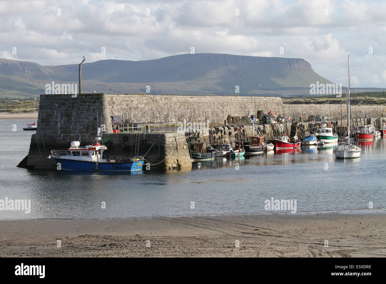 Evening sunshine on a harbour in Ireland. Boats tied to the quay in ...