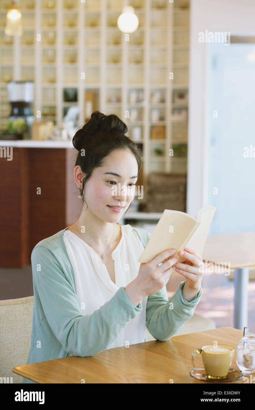 Woman reading a book in a cafe japan hi-res stock photography and ...
