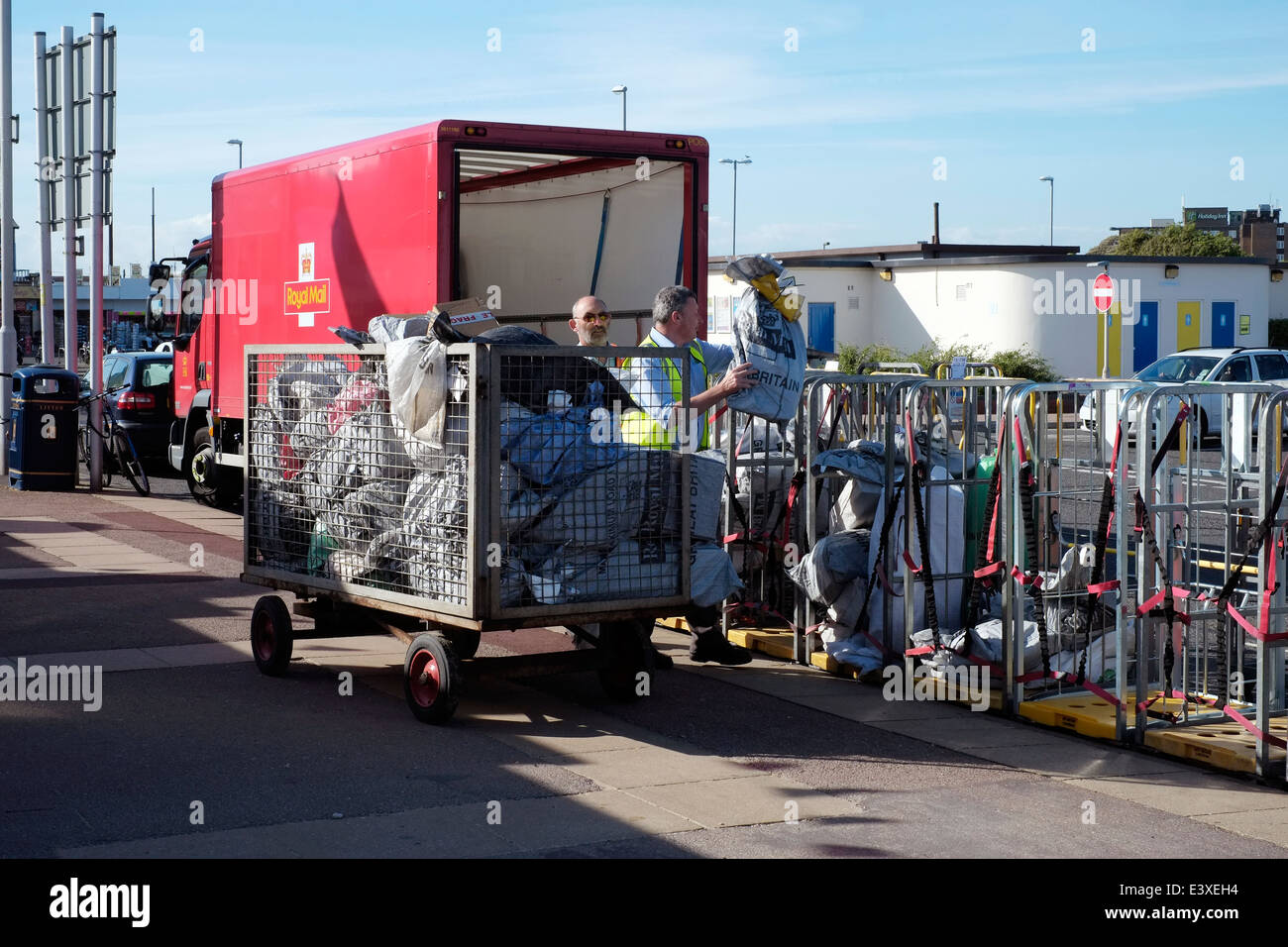 royal mail workers load mail onto trolleys after it has arrived in ...