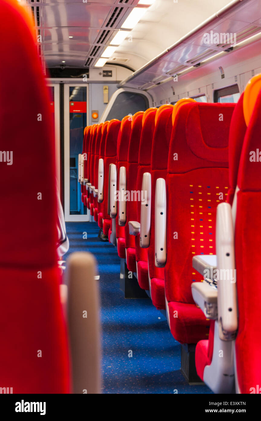 Looking along the rows of red seats on the inside of a passenger ...