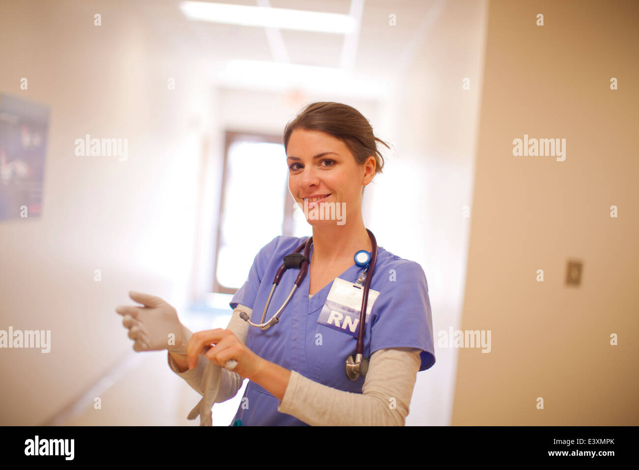 Caucasian nurse pulling on gloves in hospital Stock Photo - Alamy