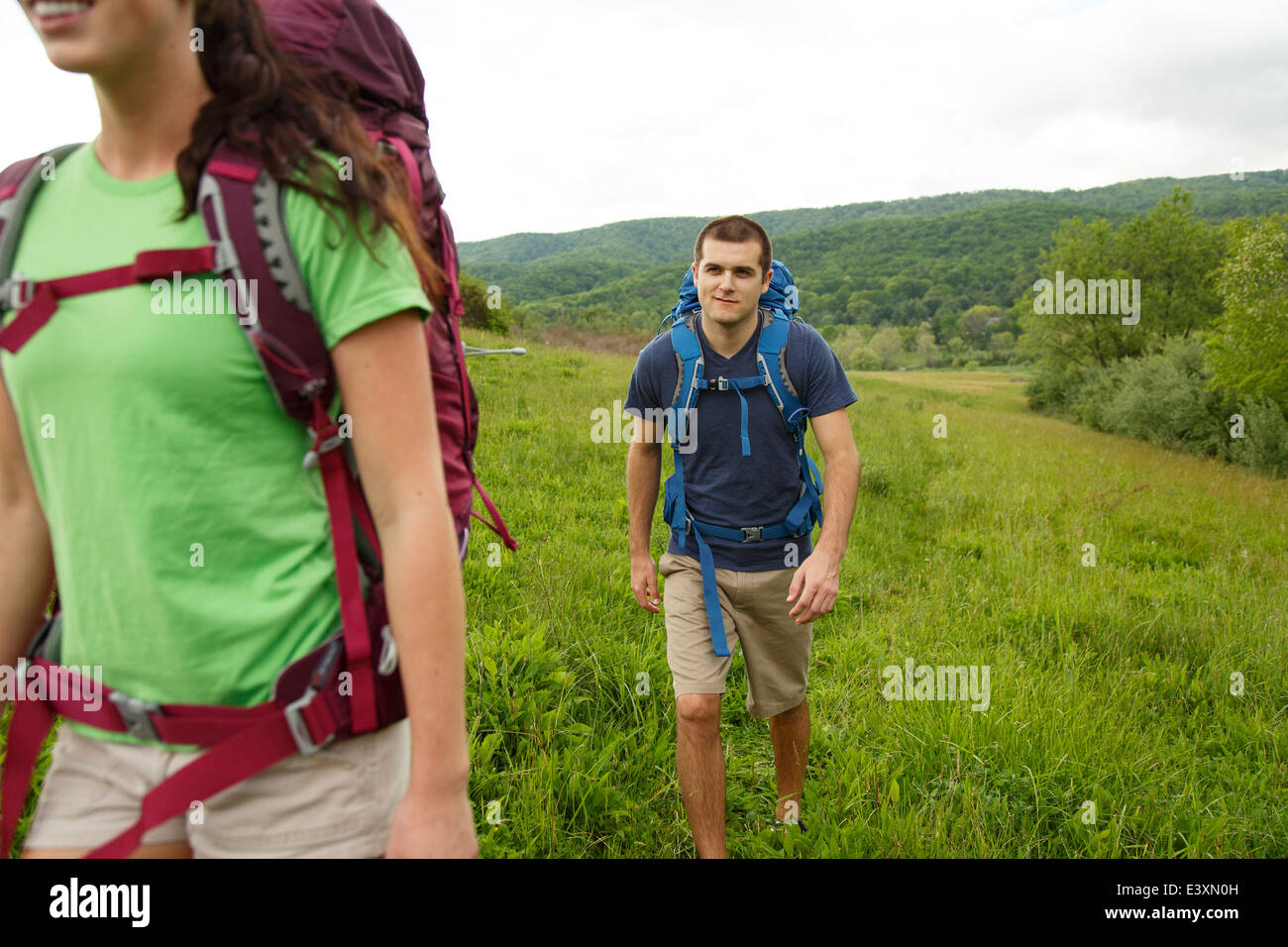 Caucasian couple hiking in rural field Stock Photo - Alamy