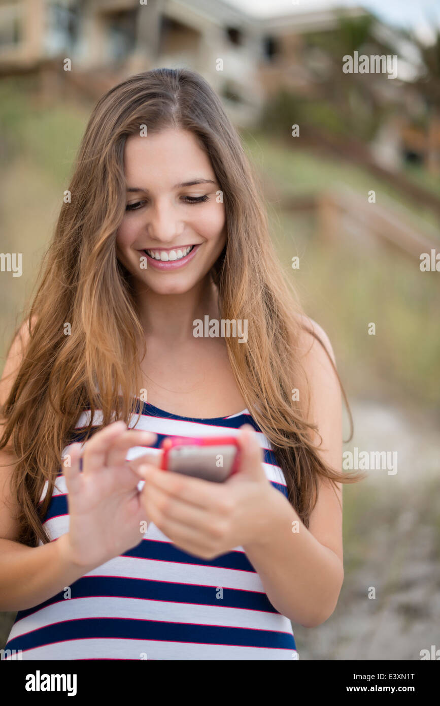 Caucasian woman using cell phone on beach Stock Photo - Alamy