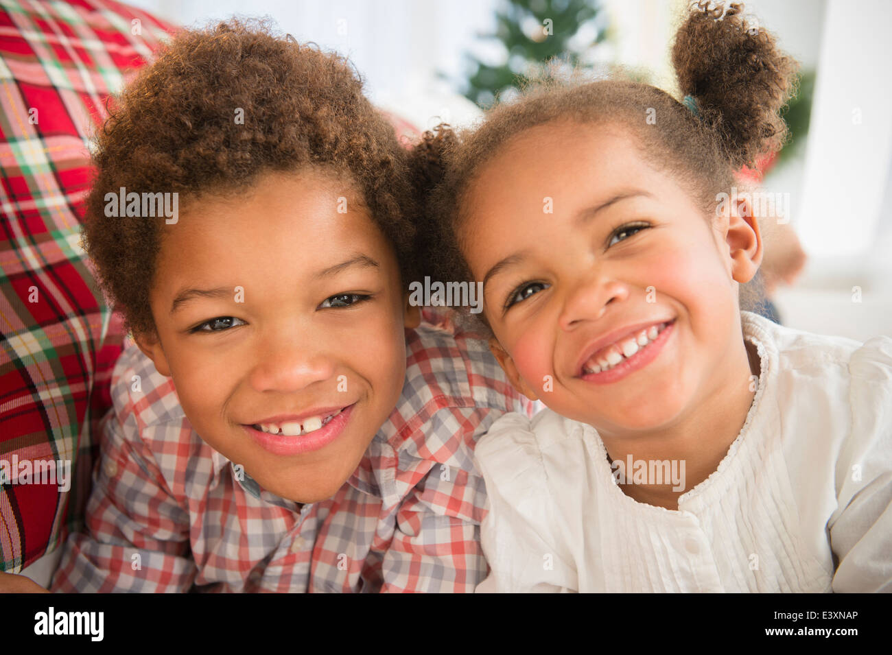 Black children smiling together on sofa Stock Photo - Alamy