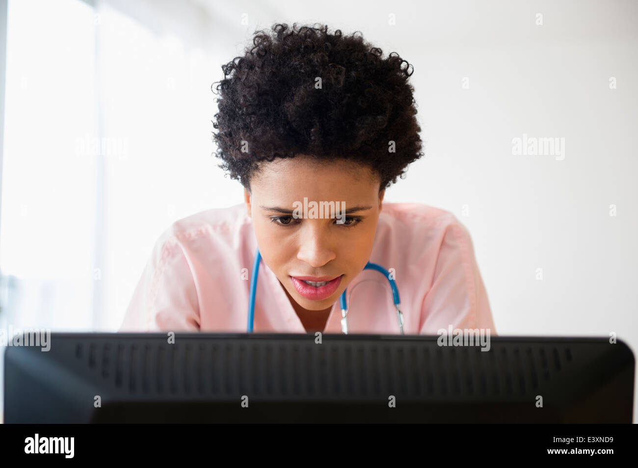 Black nurse working on computer in office Stock Photo - Alamy