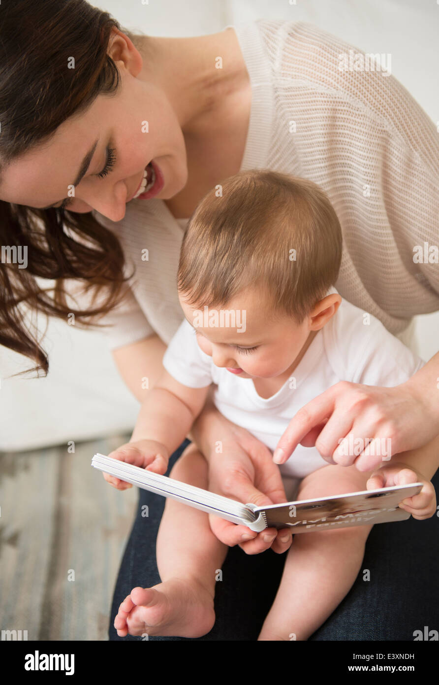 Mother and baby reading in living room Stock Photo - Alamy