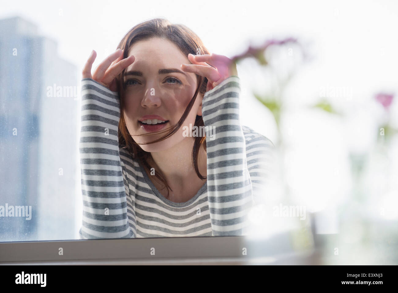 Woman peering in through window Stock Photo - Alamy