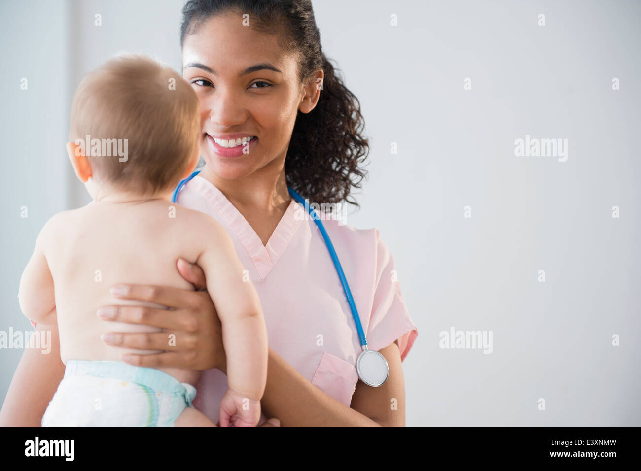 Nurse holding baby in hospital Stock Photo - Alamy