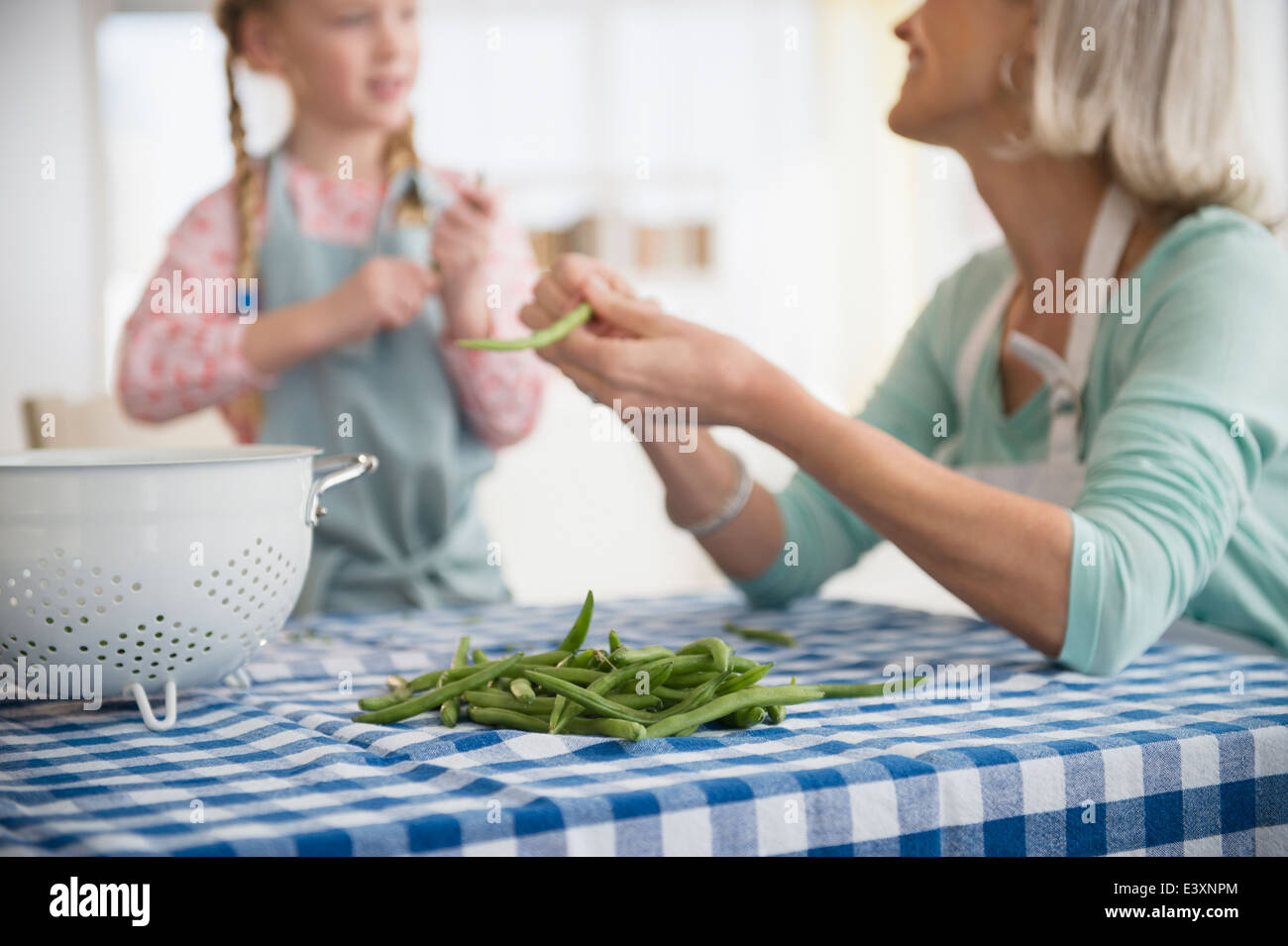 Senior Caucasian woman and granddaughter shucking peas together Stock ...