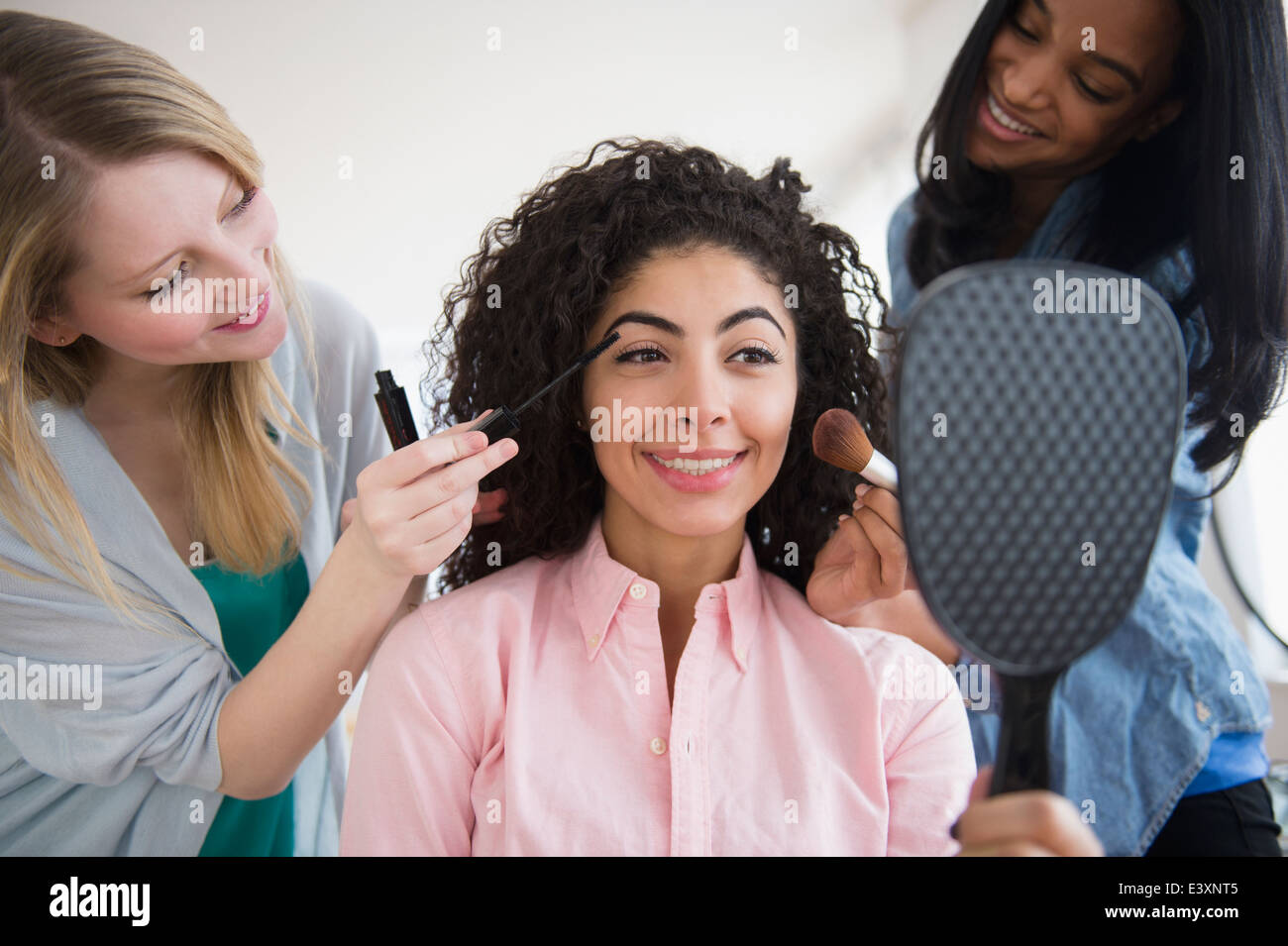 Women doing friend's makeup in mirror Stock Photo - Alamy