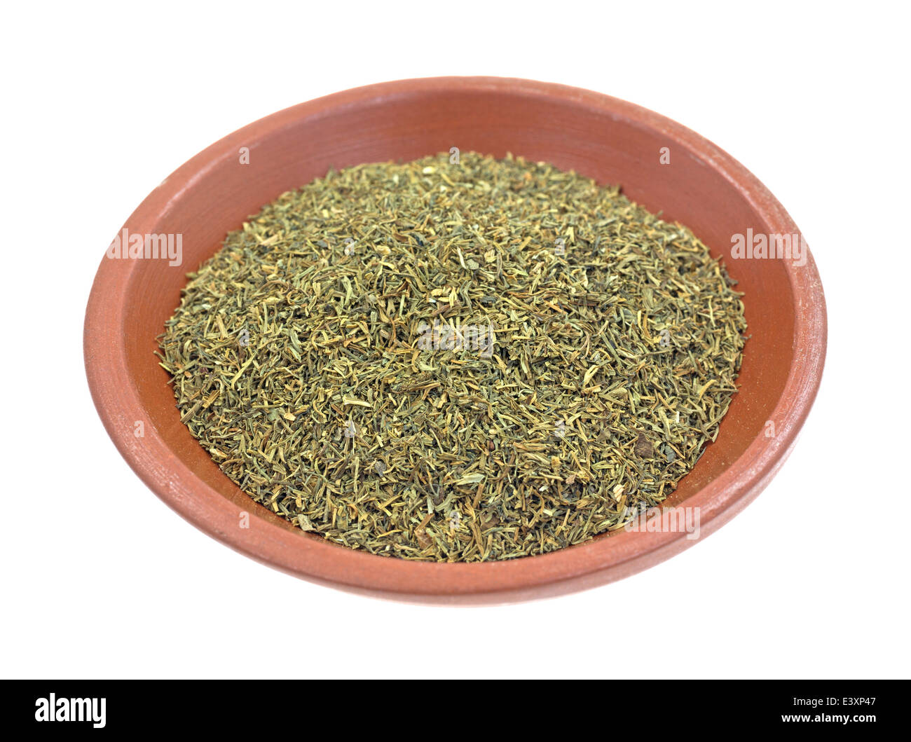 A small clay bowl with a portion of dried dill weed on a white ...