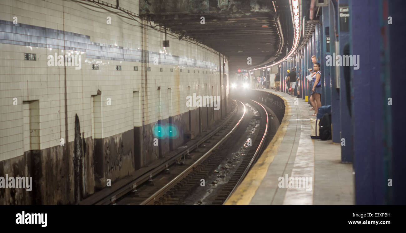 Subway riders wait for the arrival of an "F" train at the East Broadway ...