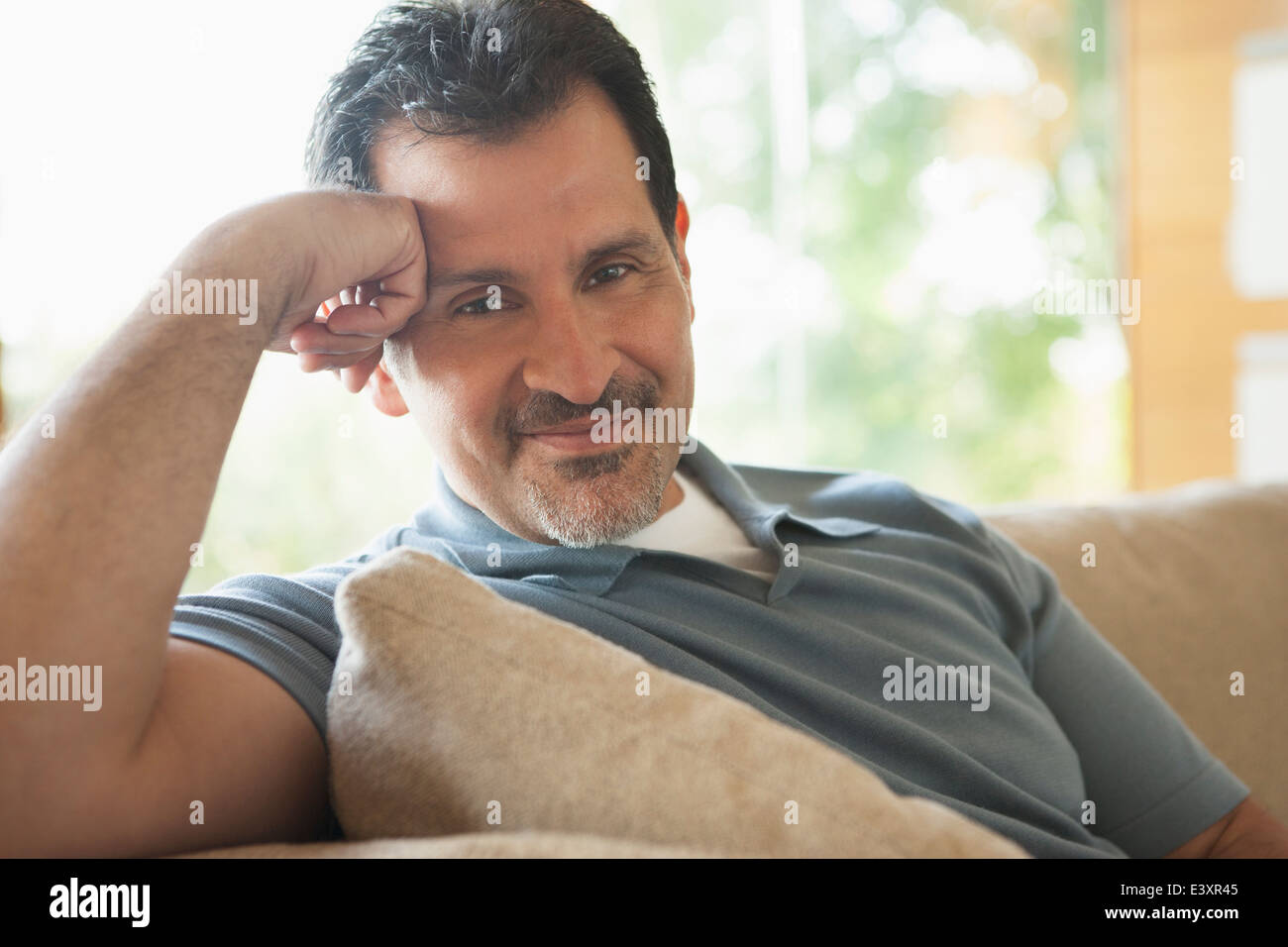 Hispanic man relaxing on sofa Stock Photo - Alamy