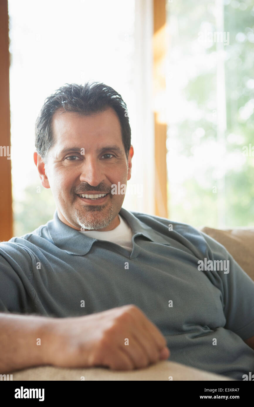 Hispanic man relaxing on sofa Stock Photo - Alamy