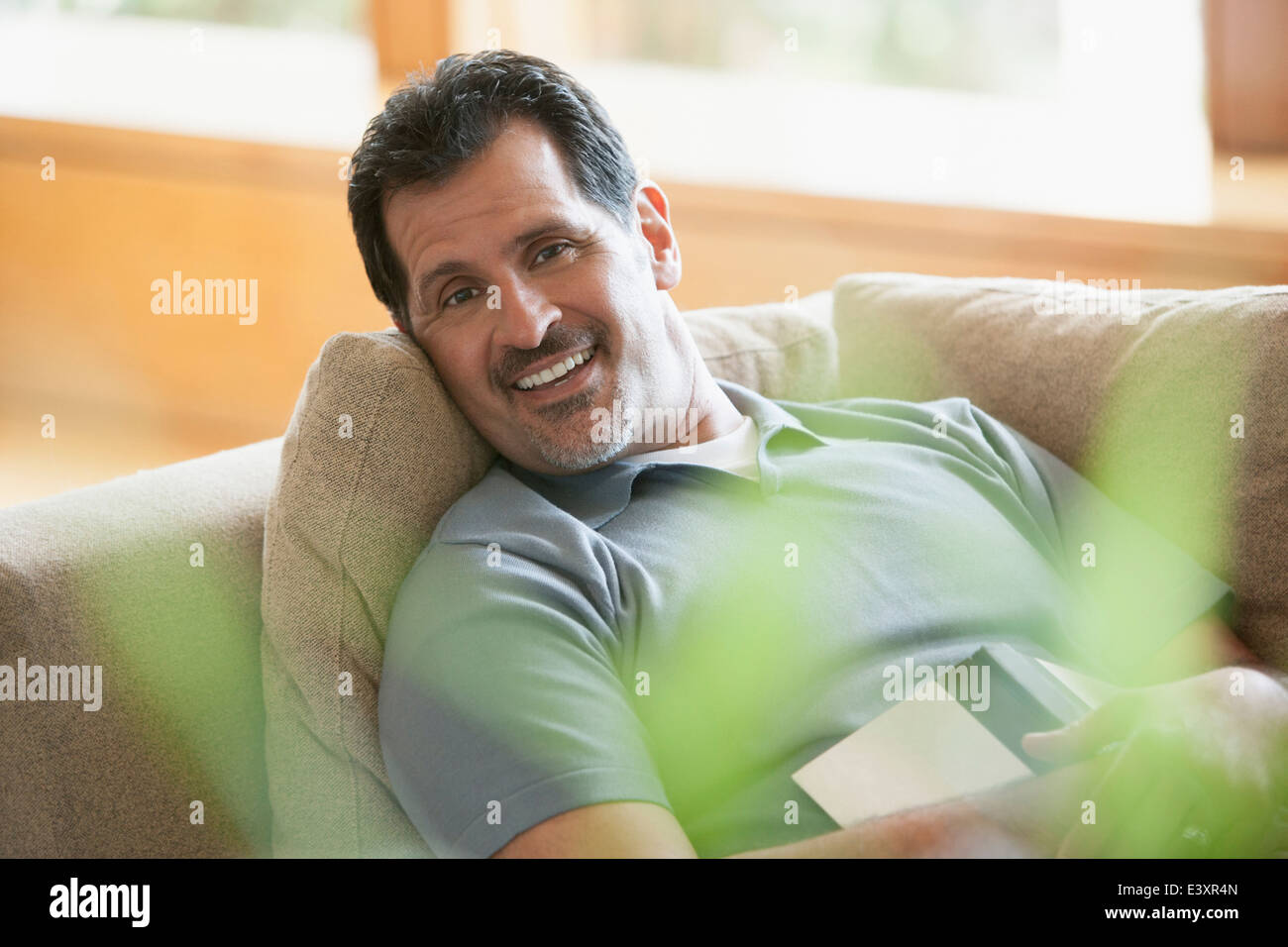 Hispanic man relaxing on sofa Stock Photo - Alamy