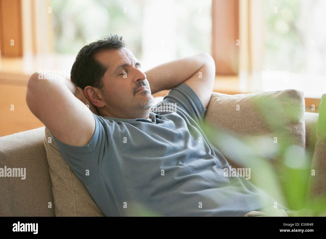 Hispanic man napping on sofa Stock Photo - Alamy