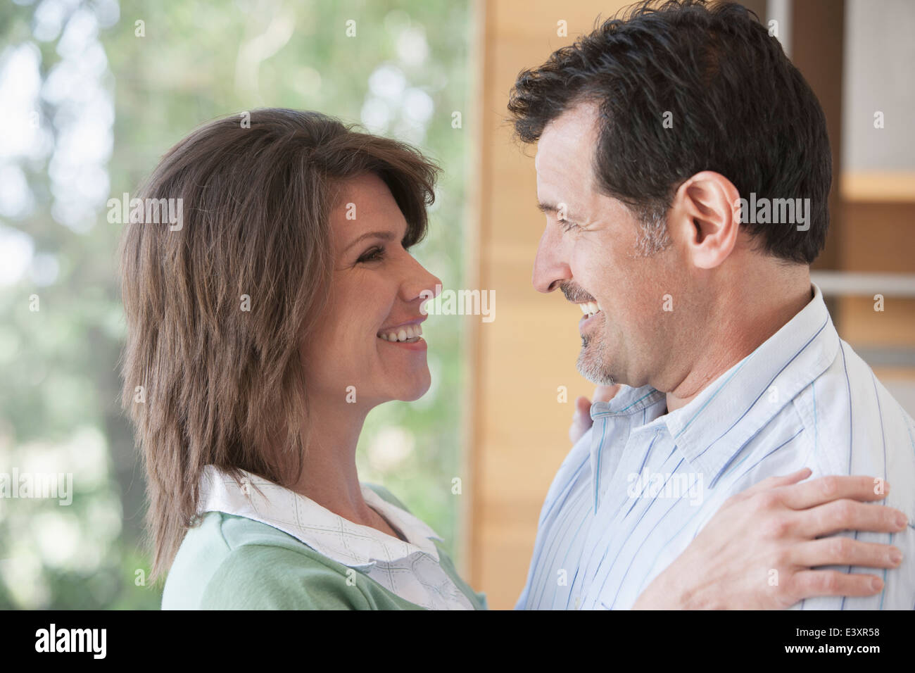 Hispanic couple hugging indoors Stock Photo - Alamy