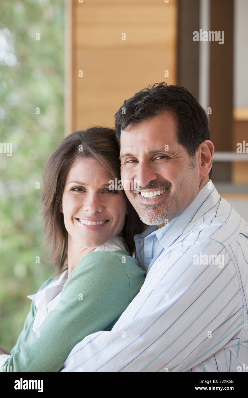 Hispanic couple hugging indoors Stock Photo - Alamy