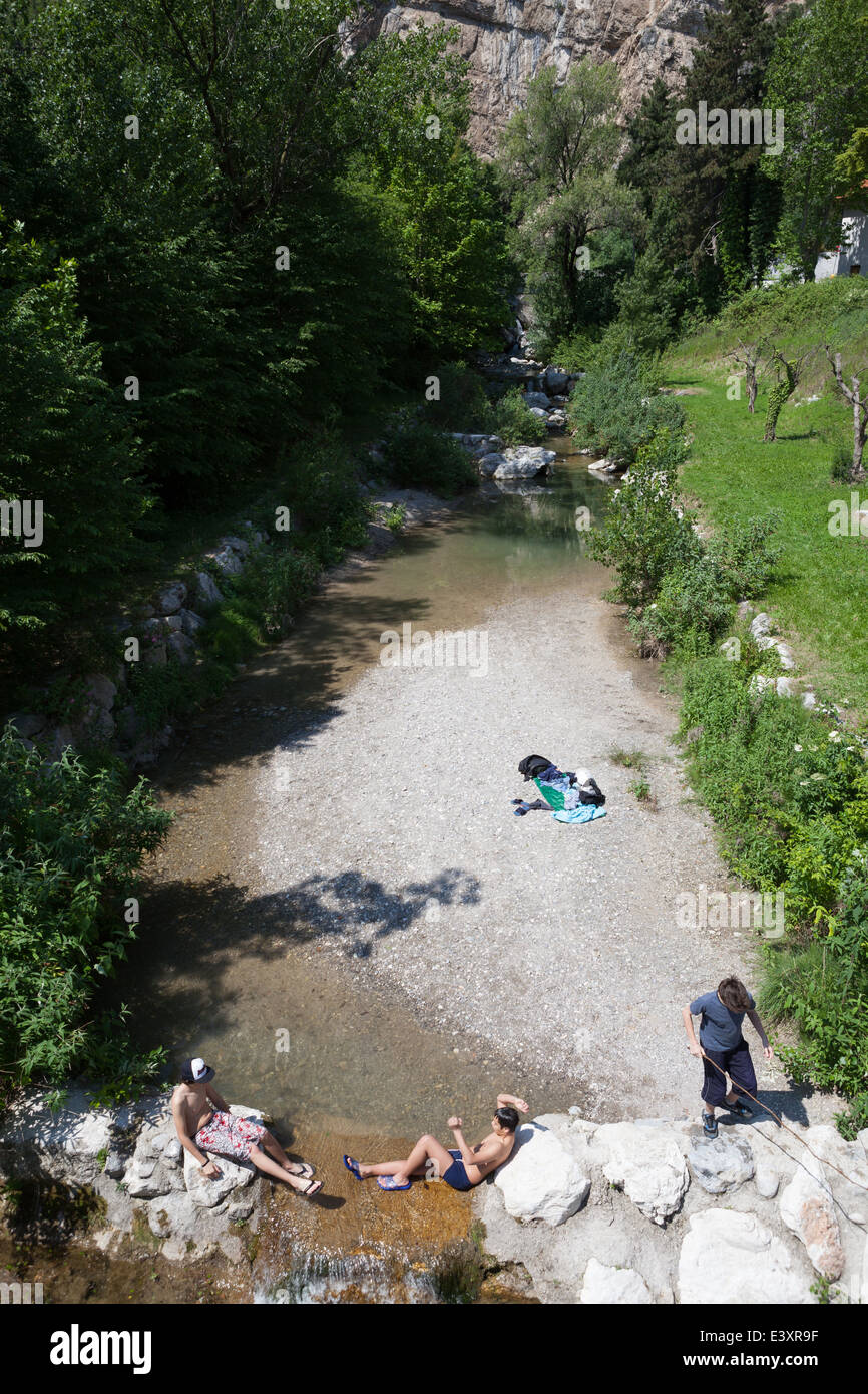 Boys sunbathing on the banks of a river. Campione del Garda, Italy ...