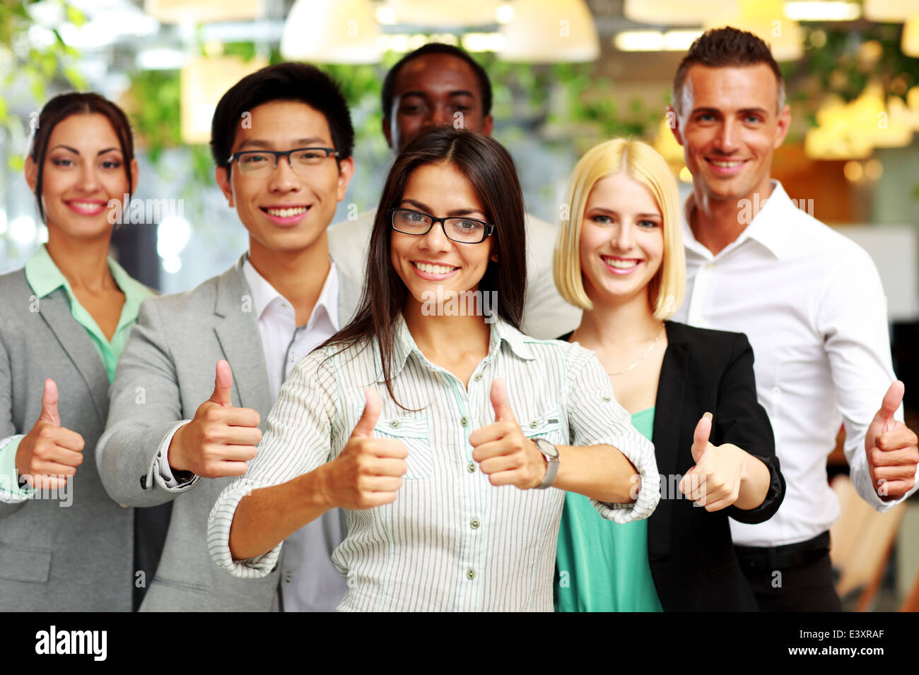 Happy business group giving thumbs up Stock Photo - Alamy