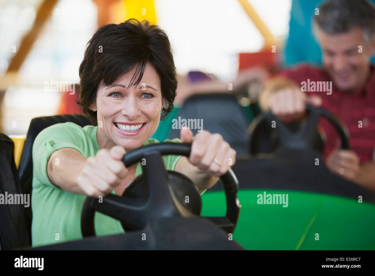 Caucasian woman driving bumper car Stock Photo - Alamy