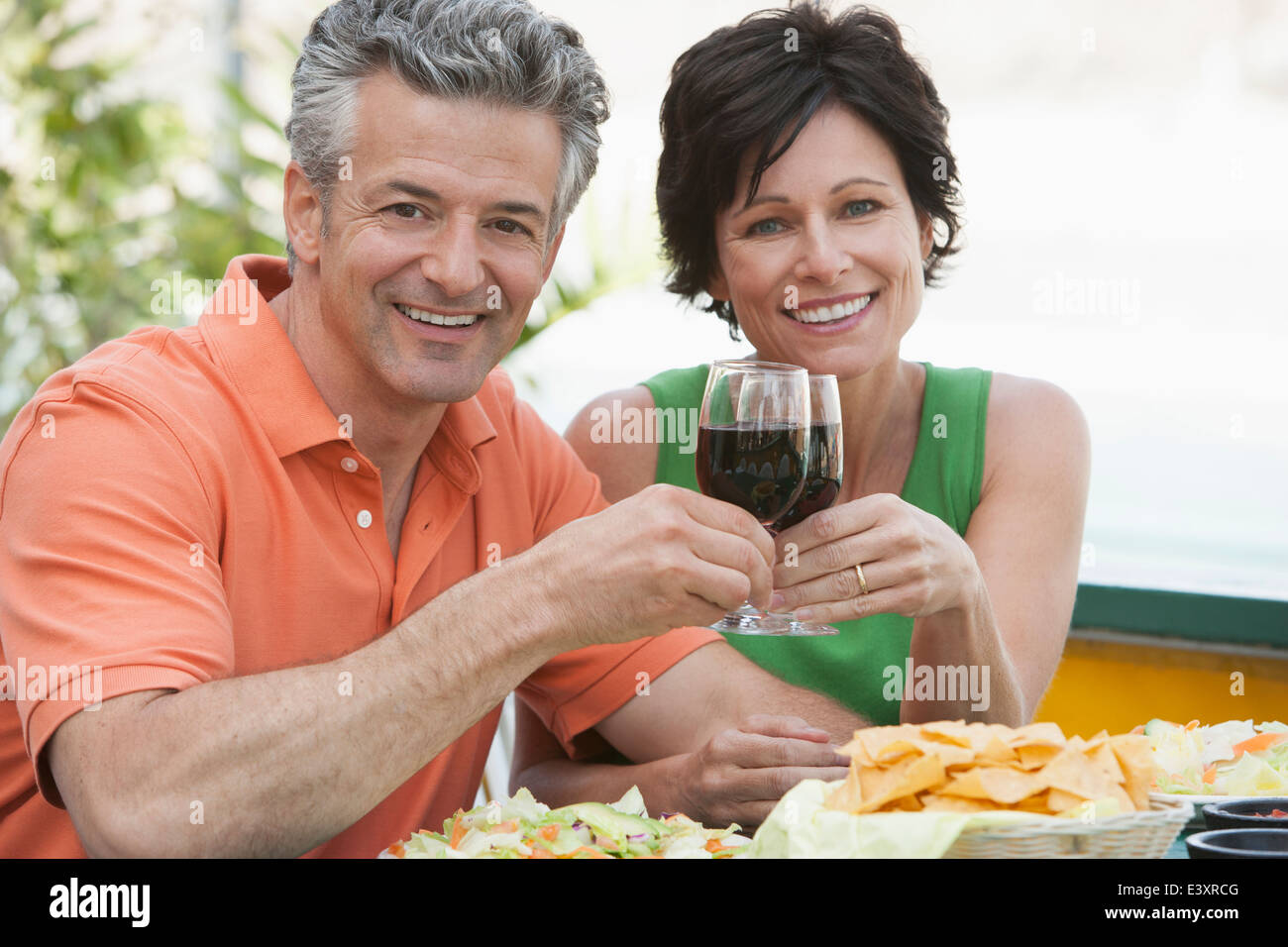 Caucasian couple toasting each other with wine Stock Photo - Alamy