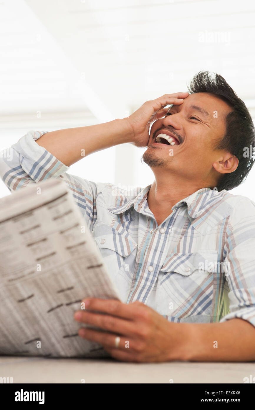 Asian man reading newspaper Stock Photo - Alamy