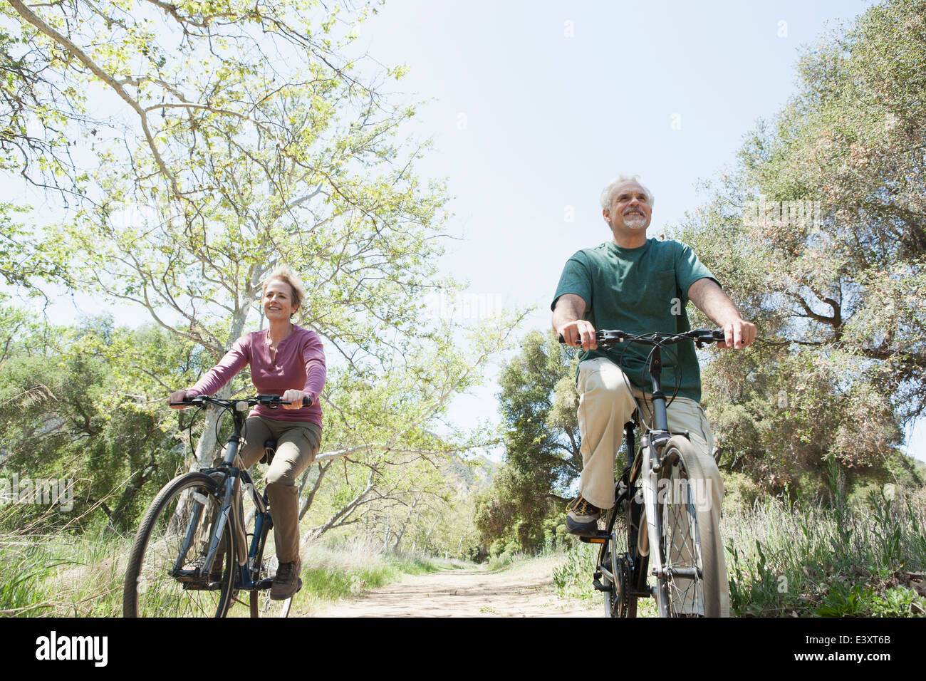 Senior Caucasian couple riding bicycles on rural path Stock Photo - Alamy