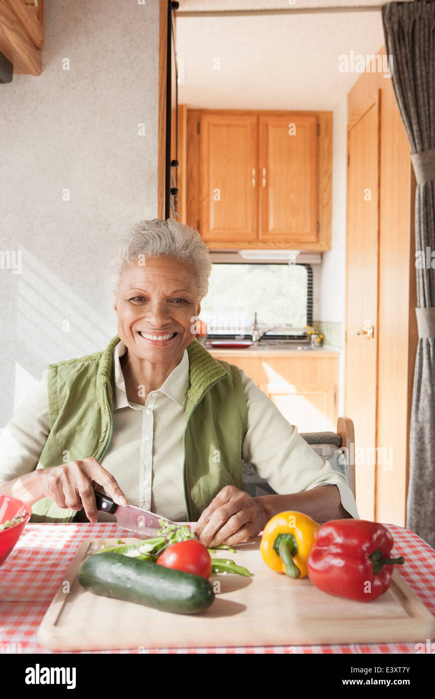 Mixed race Senior woman cooking in RV Stock Photo - Alamy