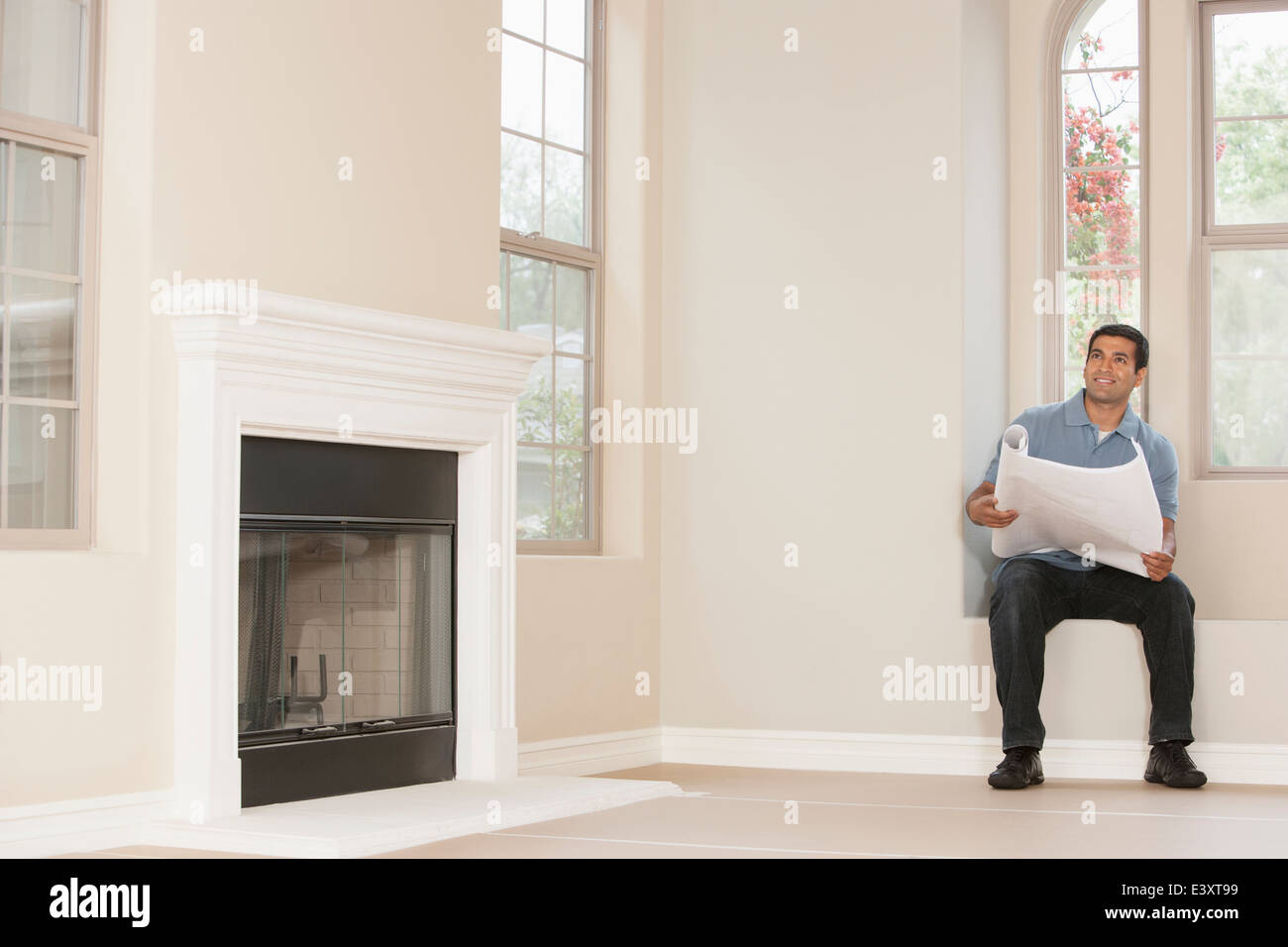 Hispanic man reading blueprints in new home Stock Photo - Alamy