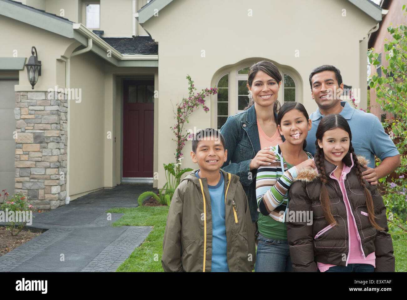 Hispanic family smiling outside home Stock Photo - Alamy