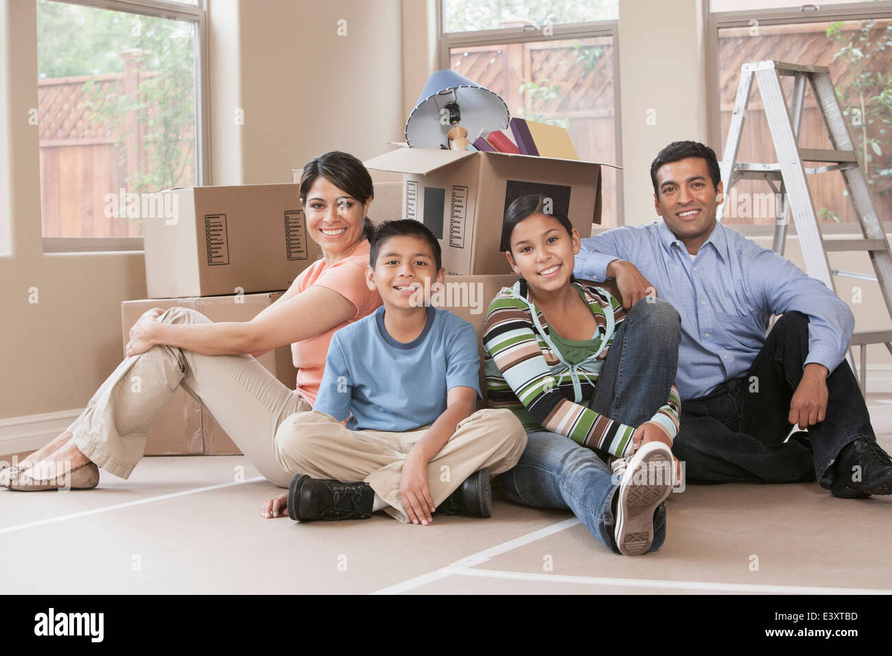 Hispanic family smiling in new home Stock Photo - Alamy