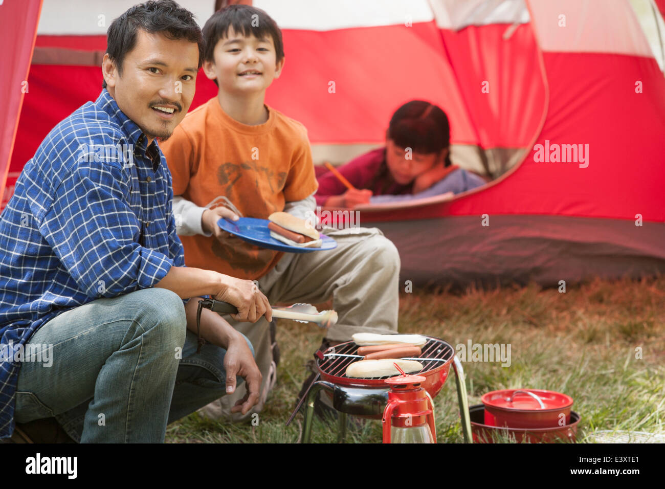 Father and son cooking at campsite Stock Photo - Alamy